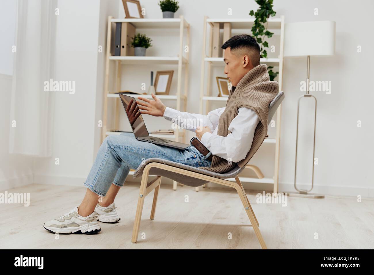 worker on a laptop in a chair in a freelance room Gray background Stock ...