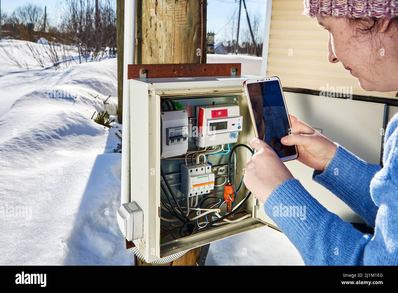 Taking readings from an electric meter in an outdoor electrical panel ...