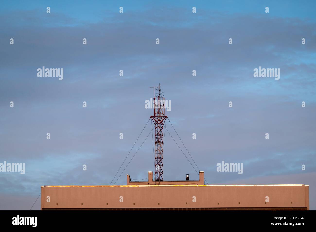 Telecommunications antenna installed on roof of modern building against ...