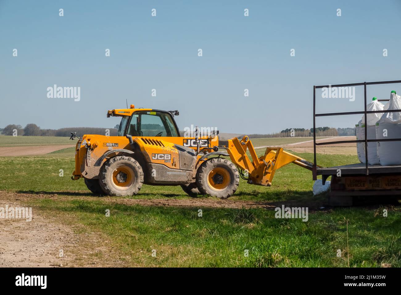 Yellow JCB agriculture fork lift truck moving 1 ton fertilizer bags ...