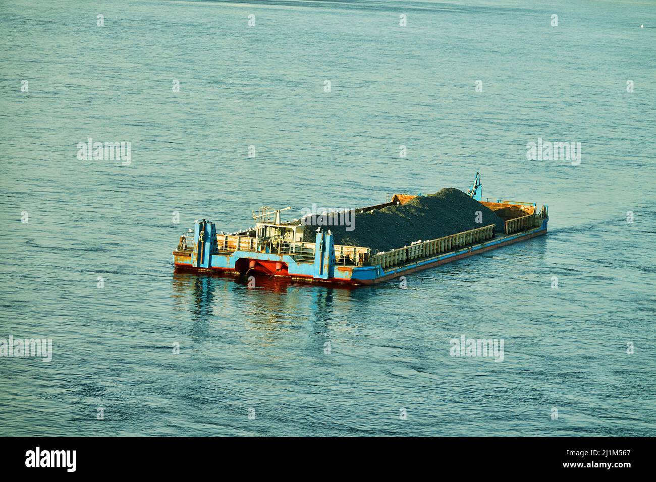 A river non-propelled barge barge (side stone dump vessel) with rubble ...