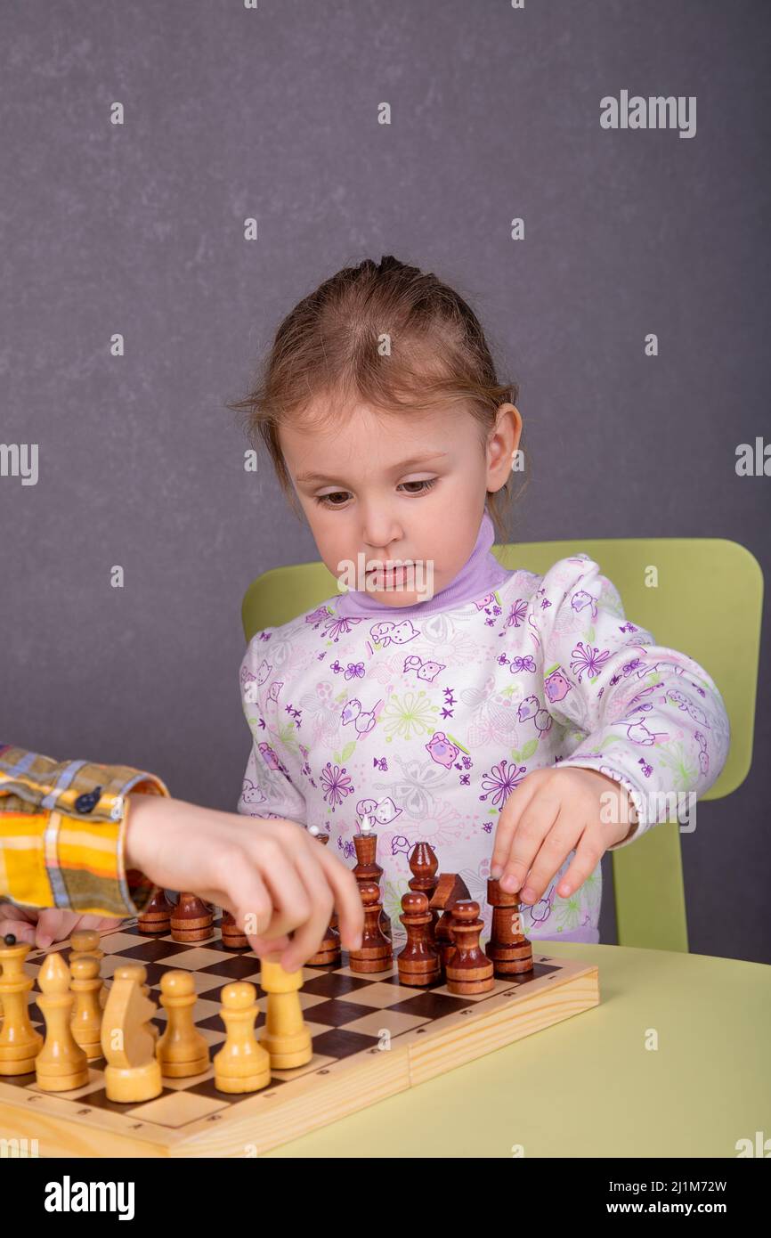 Brown-eyed little girl playing chess Stock Photo - Alamy