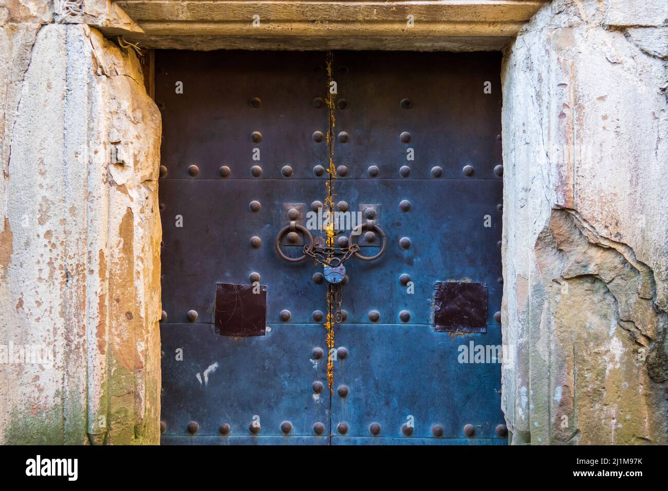 Rusty metal door with padlock located outside aged building with ...