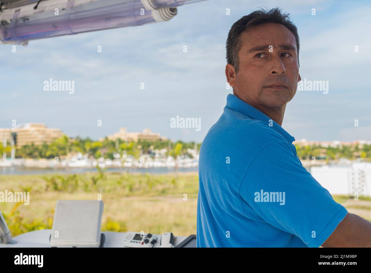 Latin captain steering his boat ready to depart Stock Photo - Alamy