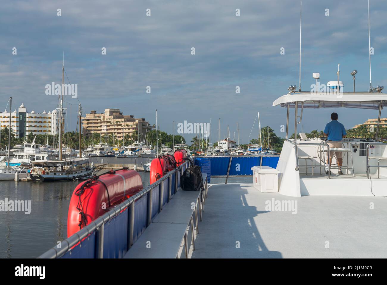 Latin captain piloting his tour boat ready to work Stock Photo - Alamy