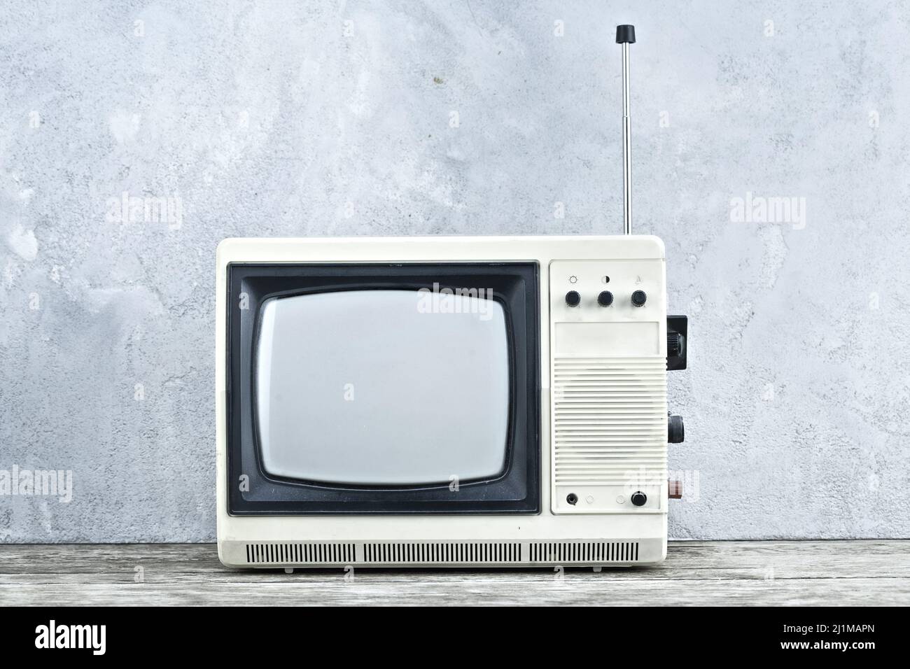 Vintage retro analog small TV set stand on wooden floor front grey ...