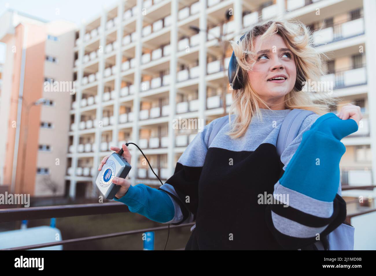 Cool 90s-inspired hipster dancing outdoors and listening to favorite ...