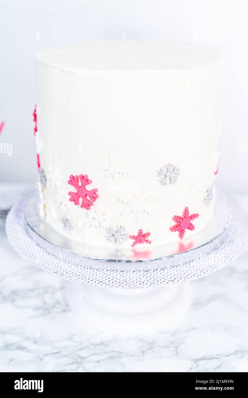 Frosting a tall round cake with white Italian buttercream icing and ...