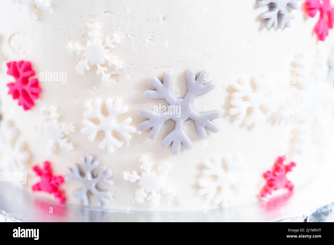 Frosting a tall round cake with white Italian buttercream icing and ...
