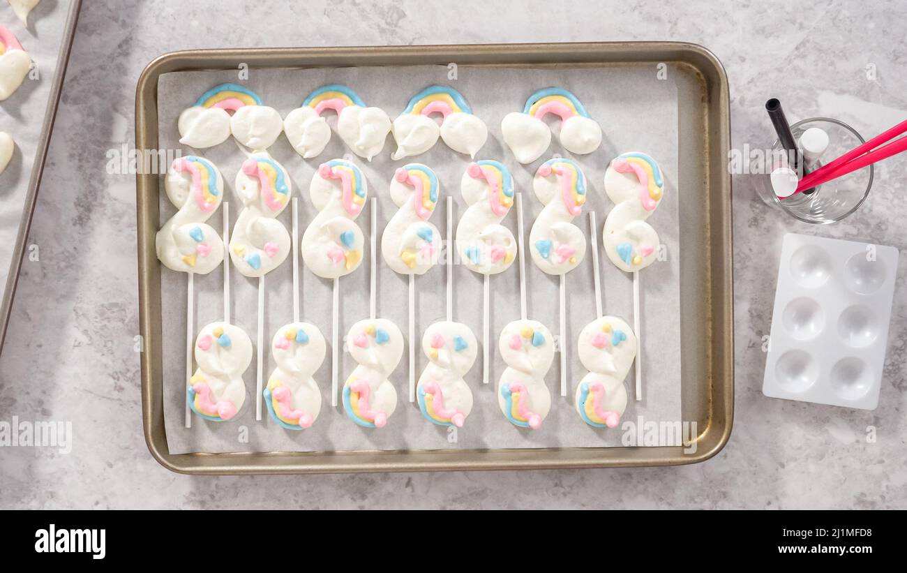 Flat lay. Step by step. Decorating freshly baked unicorn meringue pops ...