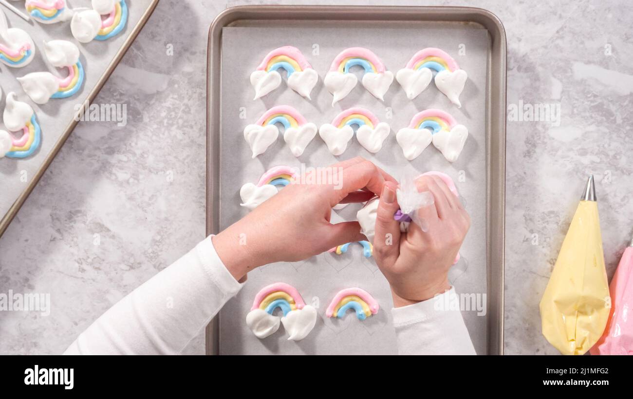 Flat lay. Step by step. Piping meringue mix into unicorn-shaped pops on ...