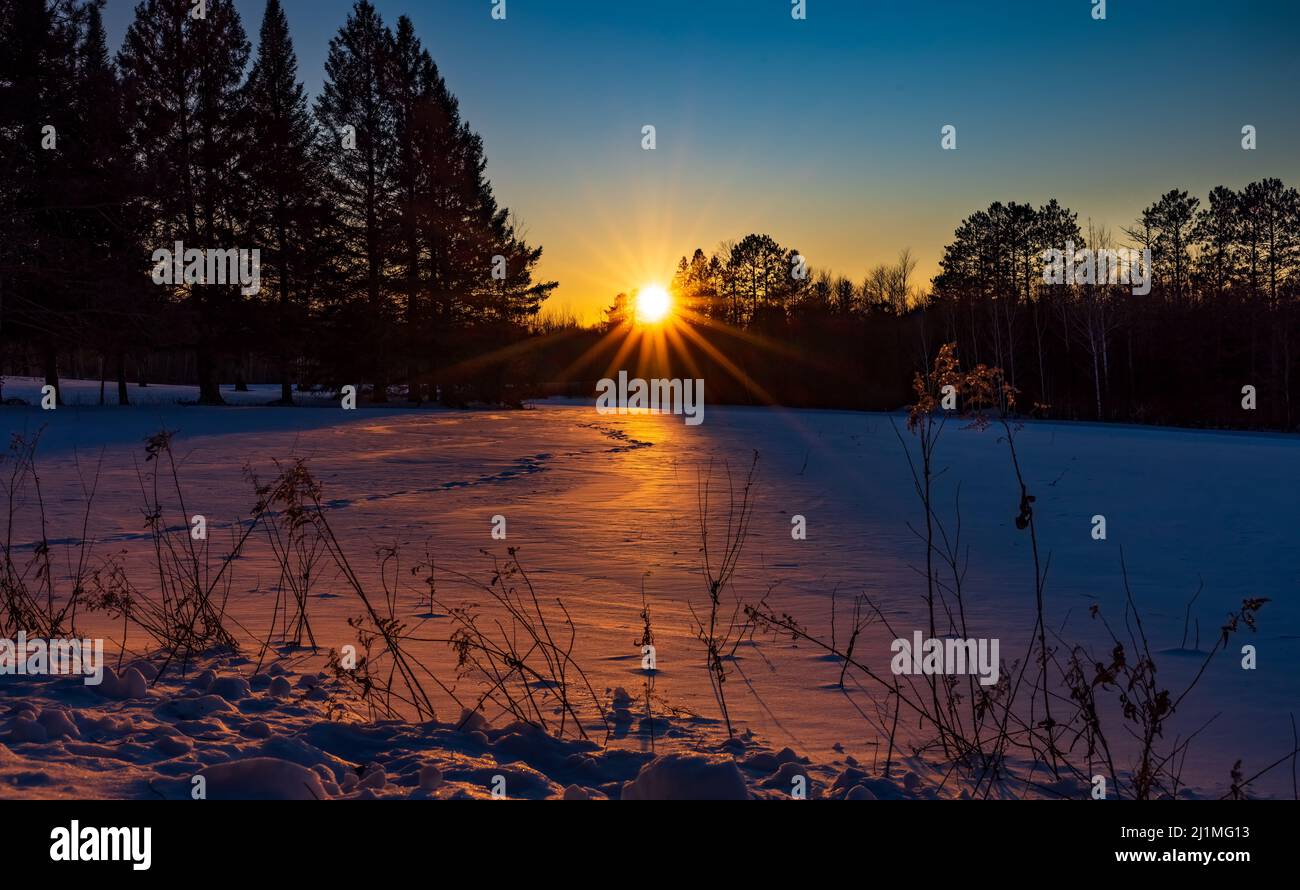 The sun setting on a cold winter's day in northern Wisconsin Stock ...