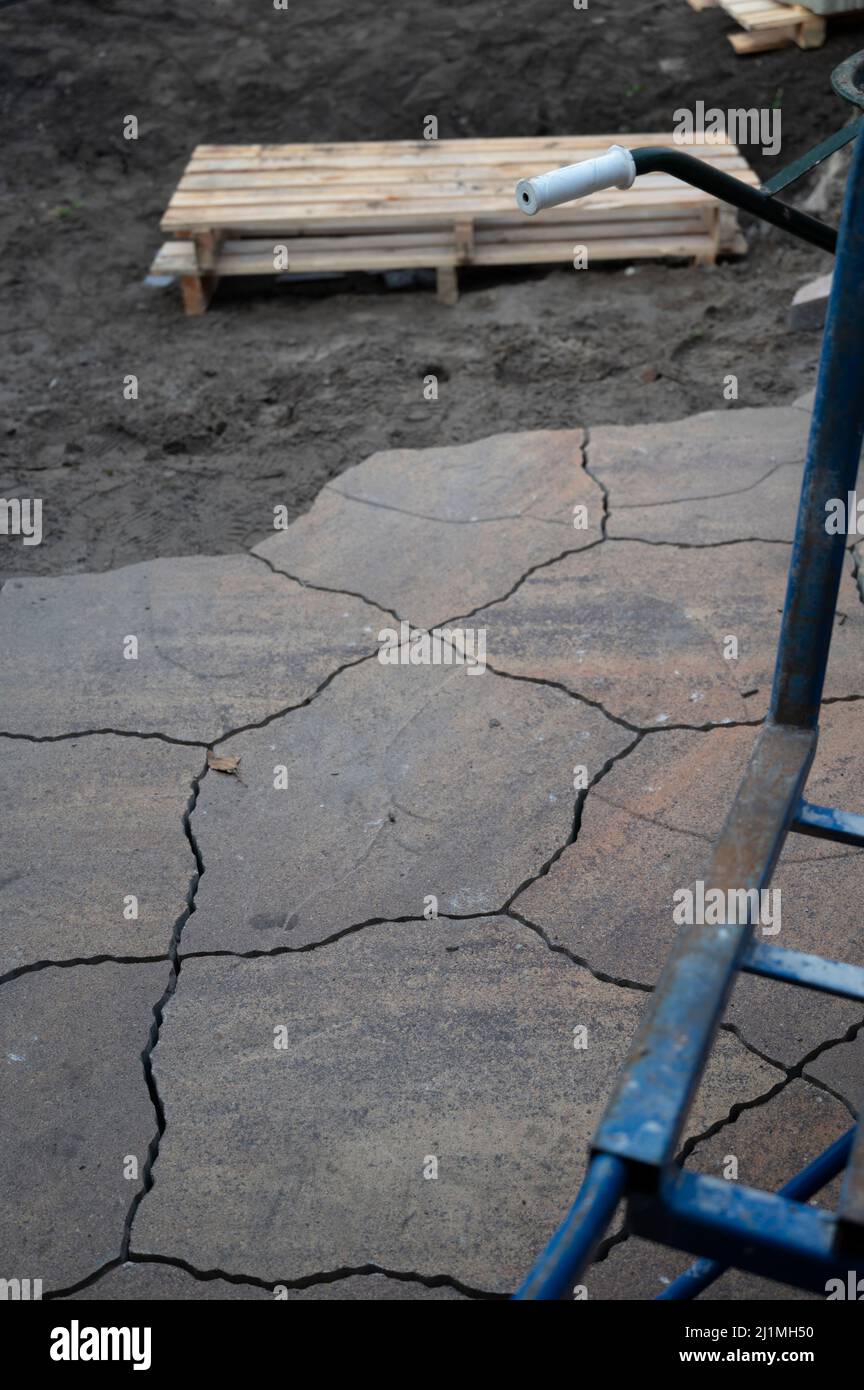 Work on laying irregularly shaped concrete tiles in the garden during ...