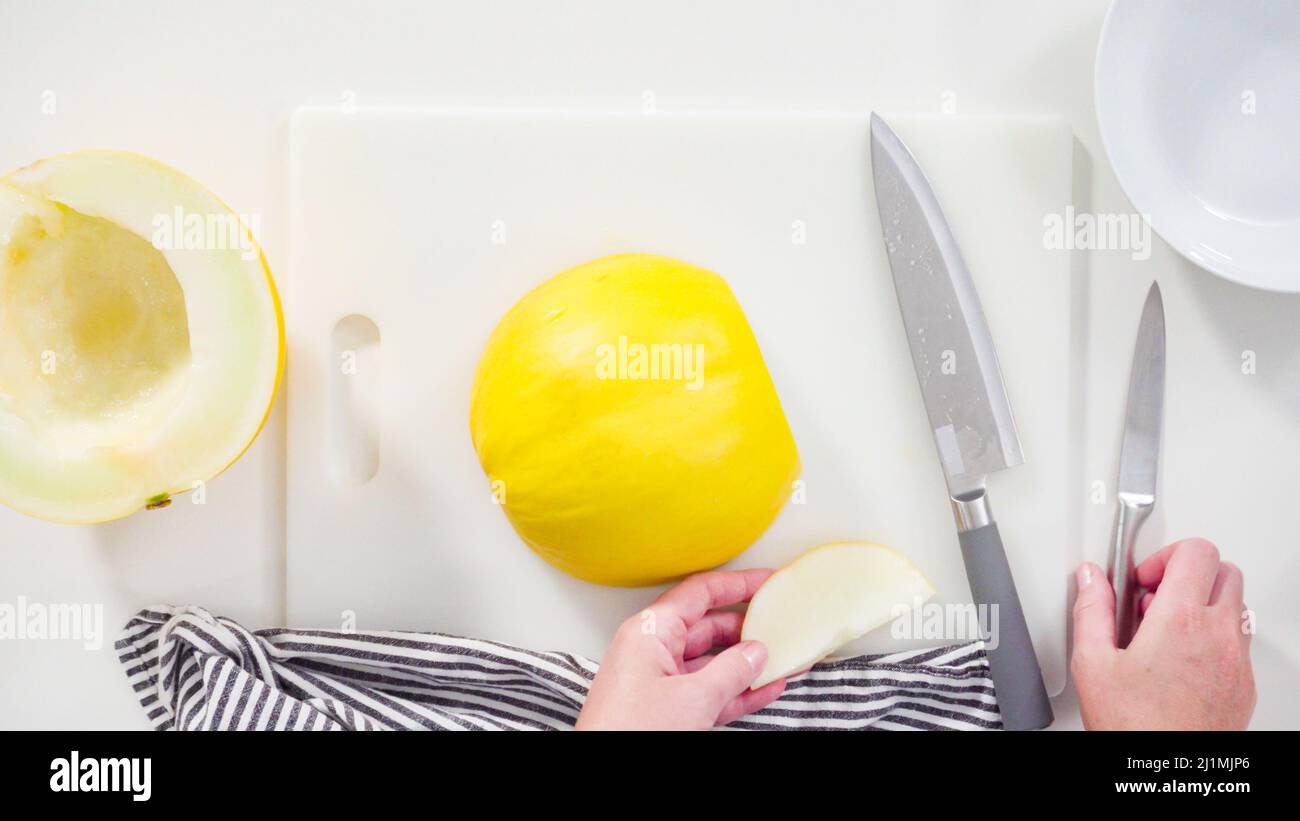 Step by step. Flat lay. Slicong golden dewlicious melon on a white ...