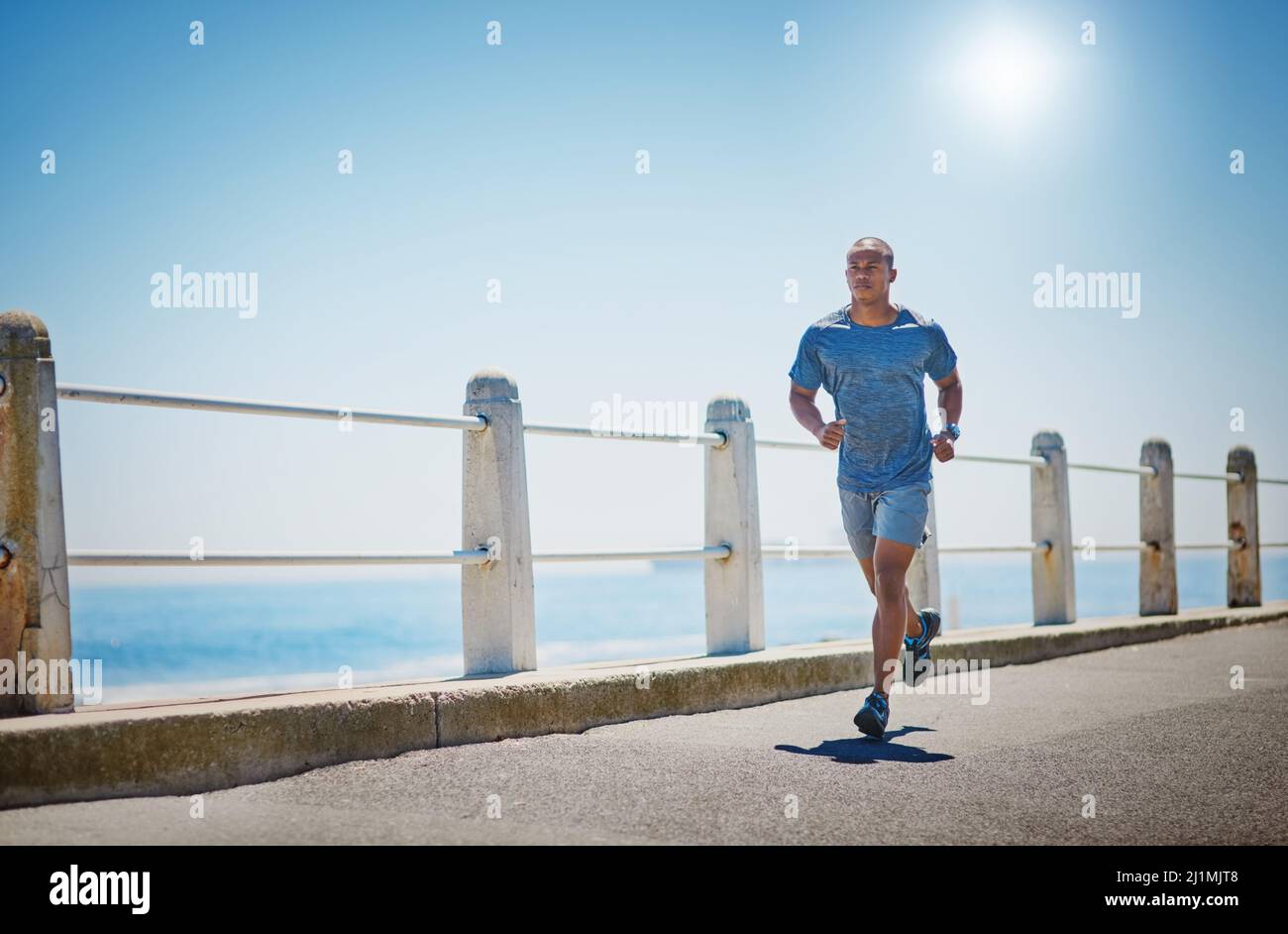 Fit and in form. Shot of a young sporty man running outside Stock Photo ...