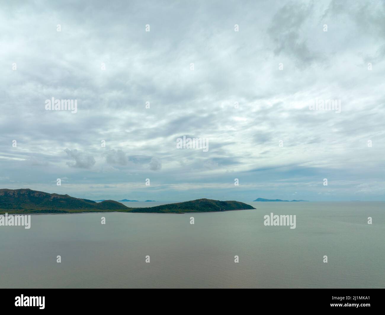 A peninsula of land jutting into the ocean with a calm sea and overhead ...