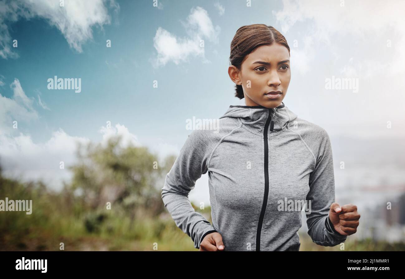 Keep your lead ahead of the pact. Shot of a sporty young woman running ...