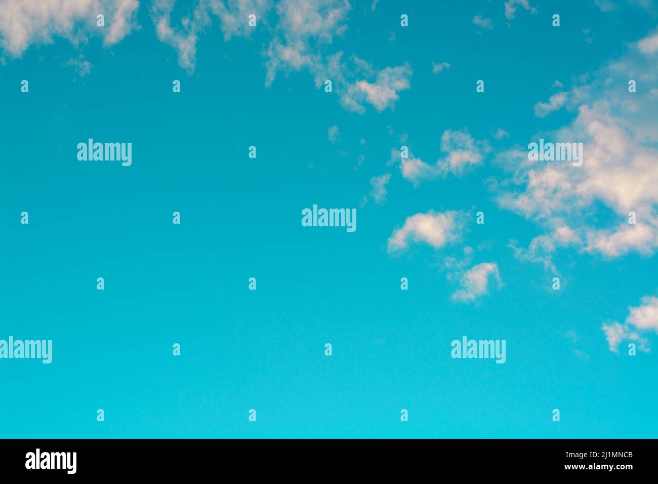 Background with turquoise sky and few small clouds with copy space in ...