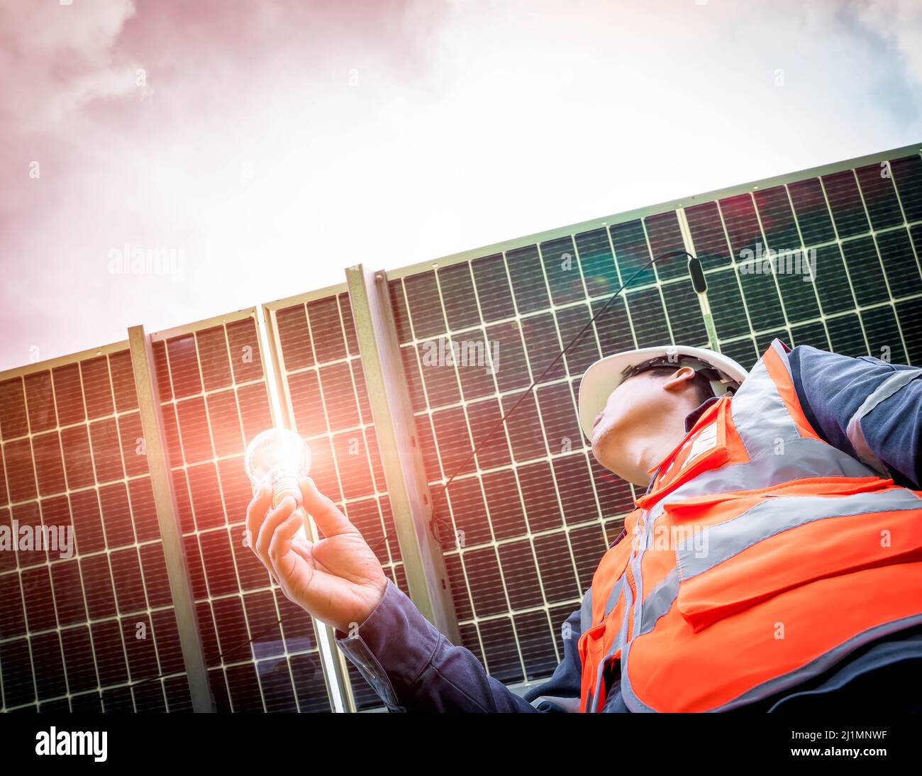Technician holding the light bulb and the sun shines into the bulb and ...