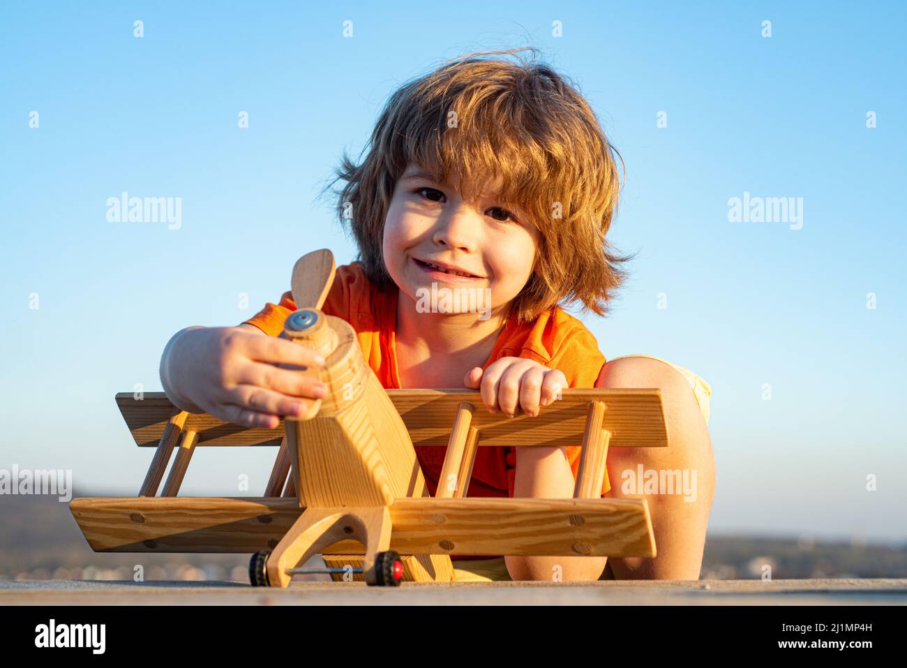 Little boy with wooden plane, boy wants to become pilot and astronaut ...