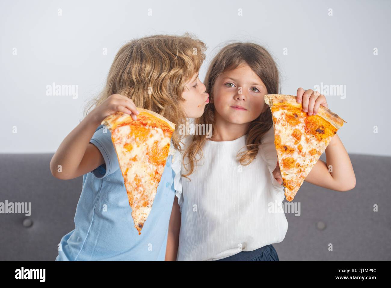 Hungry kids eating pizza. Happy children eating pizza and having fun ...