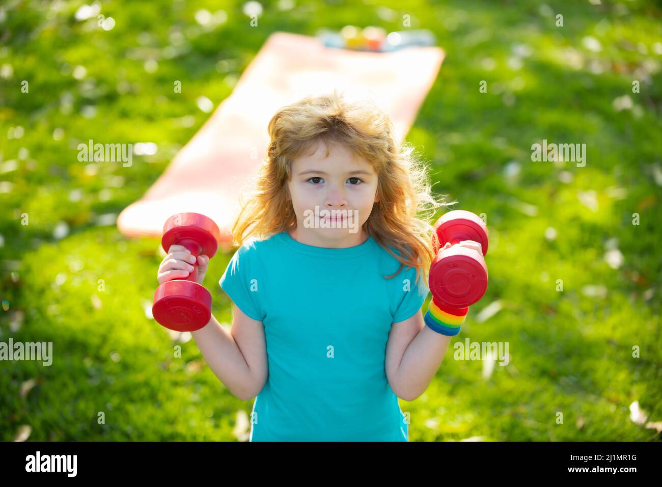 Sporty portrait kids. Fitness child with dumbbells in park. Gym workout. Child sportsman ...