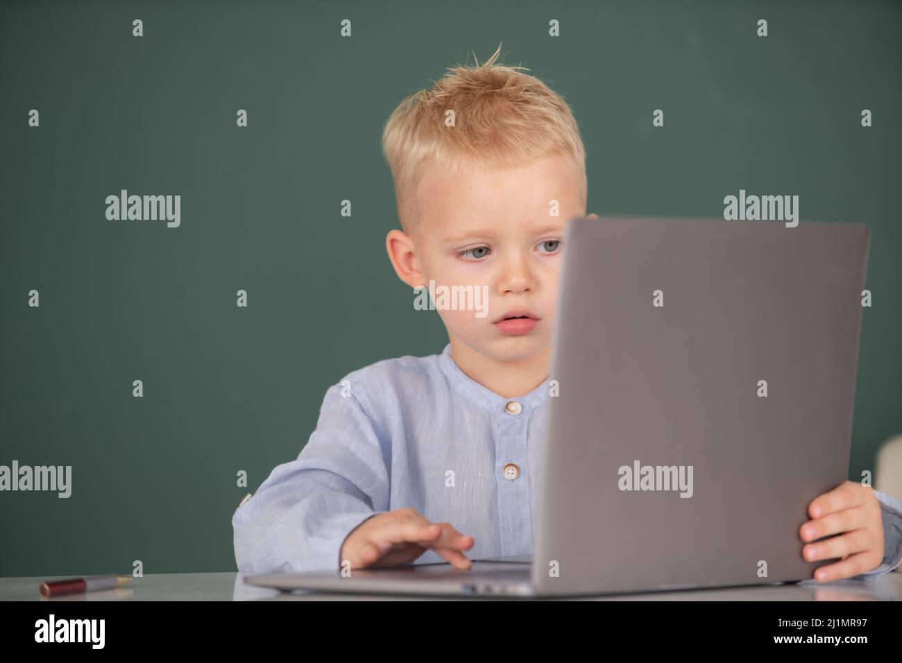 Elementary school kid working in computer class. Cute pupil face ...