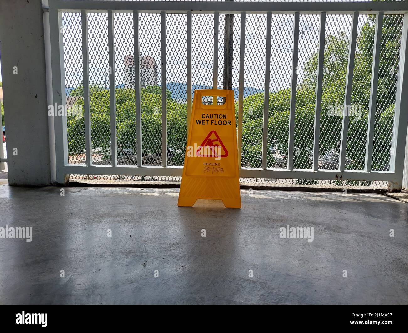 A "Caution. Wet Floor" sign on a balcony Stock Photo - Alamy