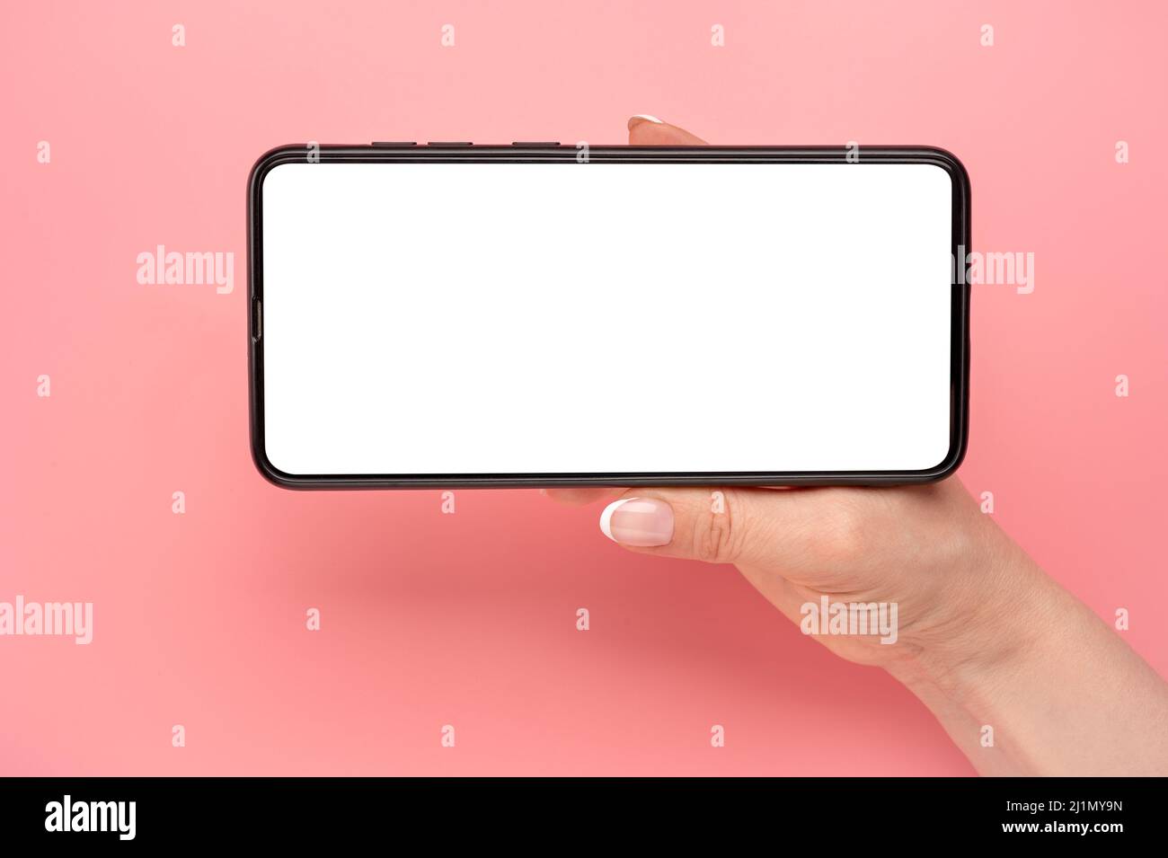Hand holding mobile phone in horizontal position for mockup. watching ...