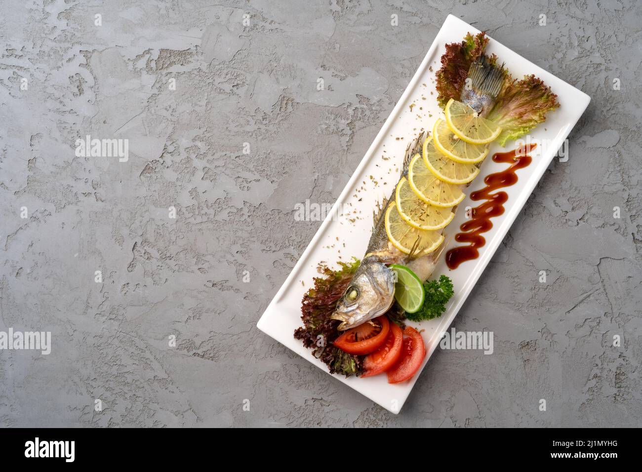 Fresh sea fish with lemon on plate Stock Photo - Alamy