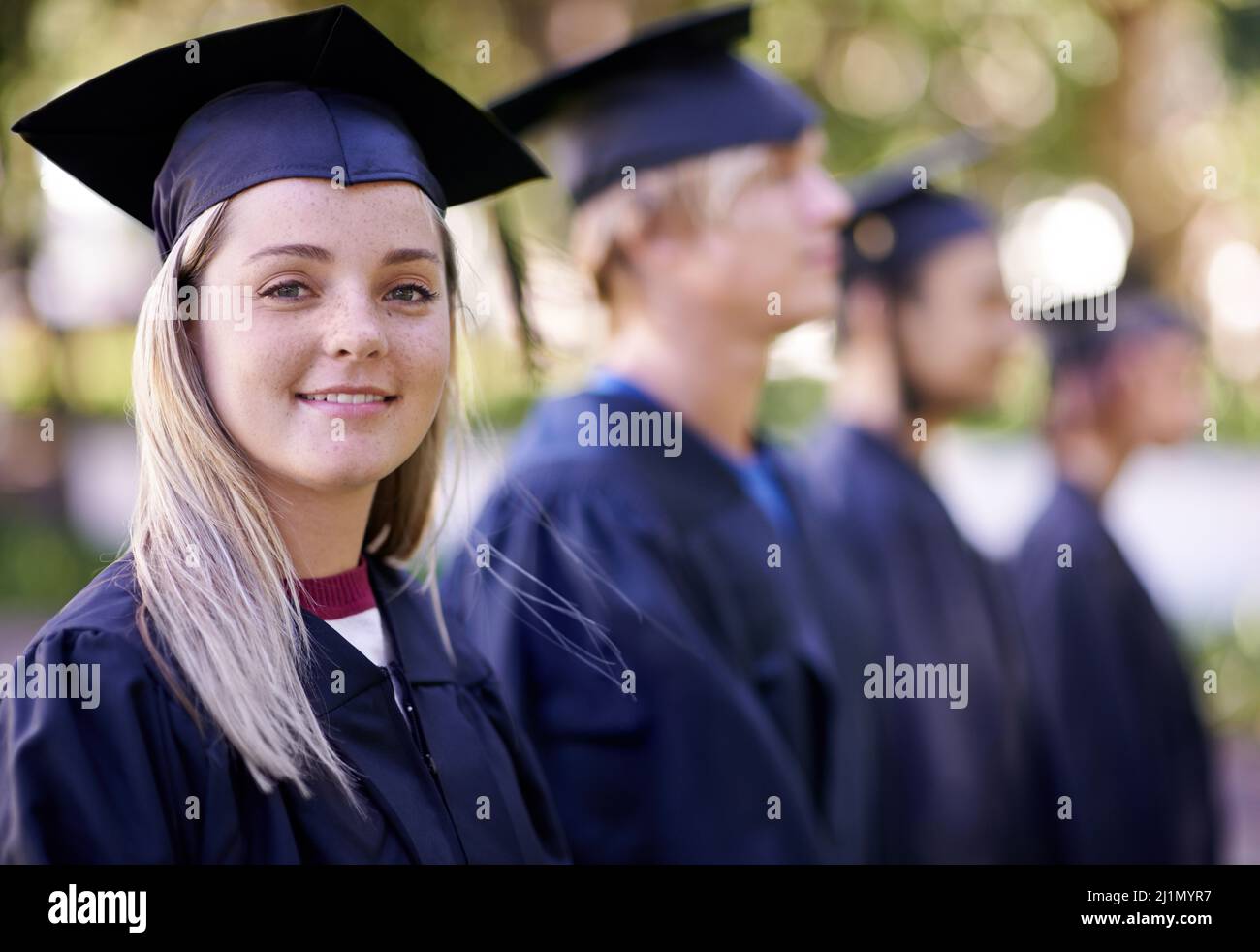 Securing her future. Portrait of a happy graduate standing in a row ...