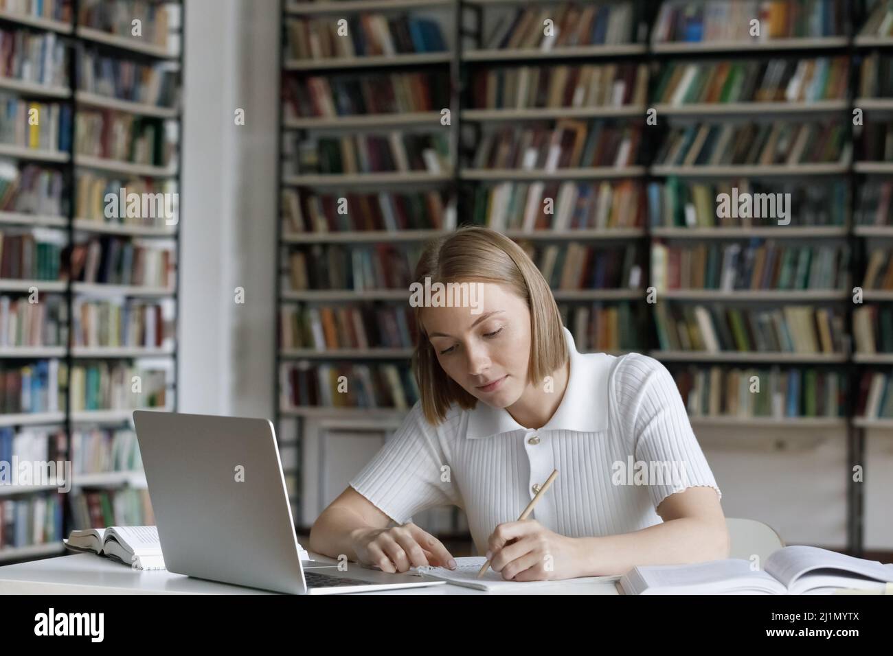 Student prepare for test writing in copybook sit in library Stock Photo ...