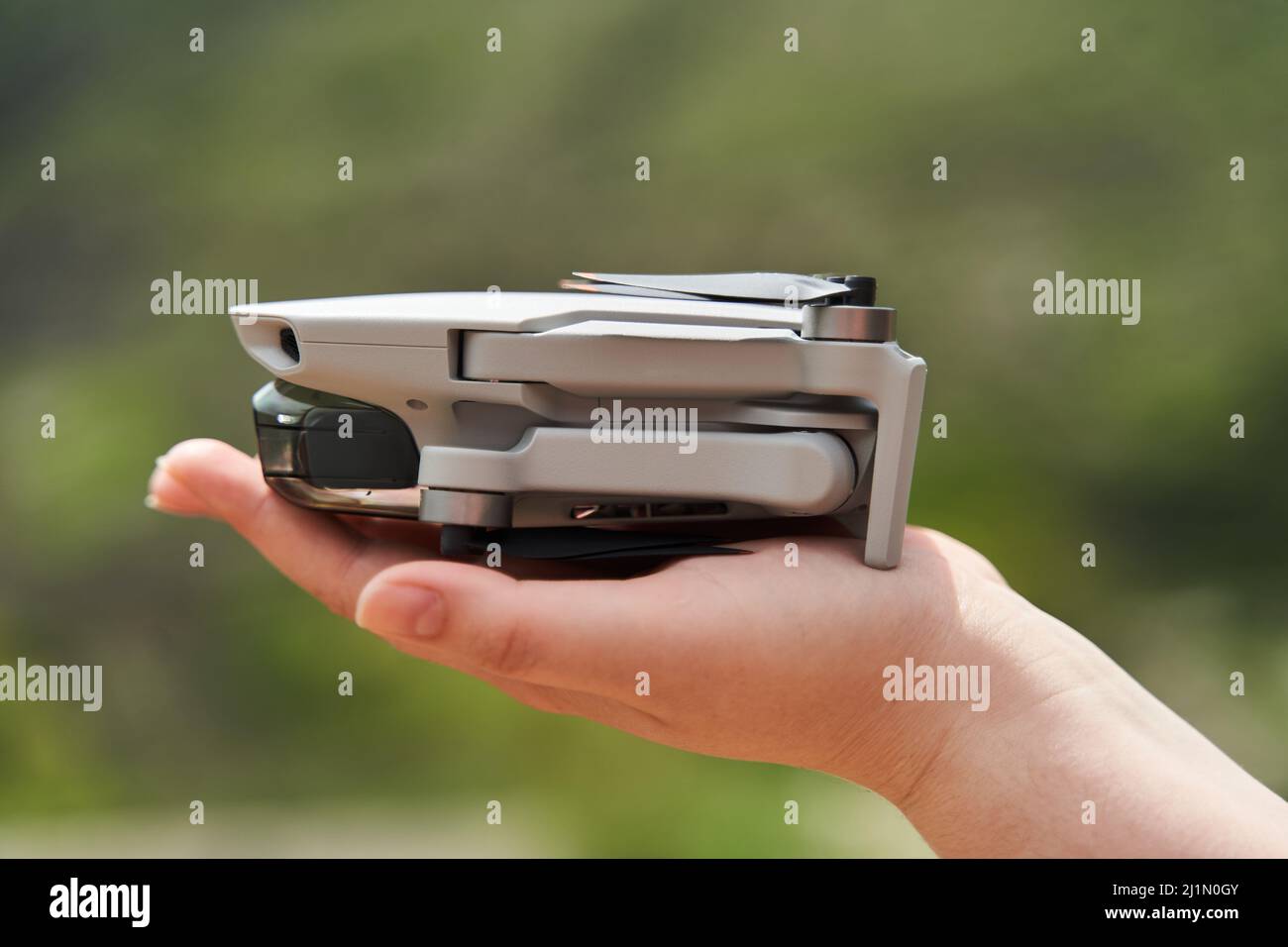 Modern small compact quadcopter in a girl's hand. Launching a drone ...