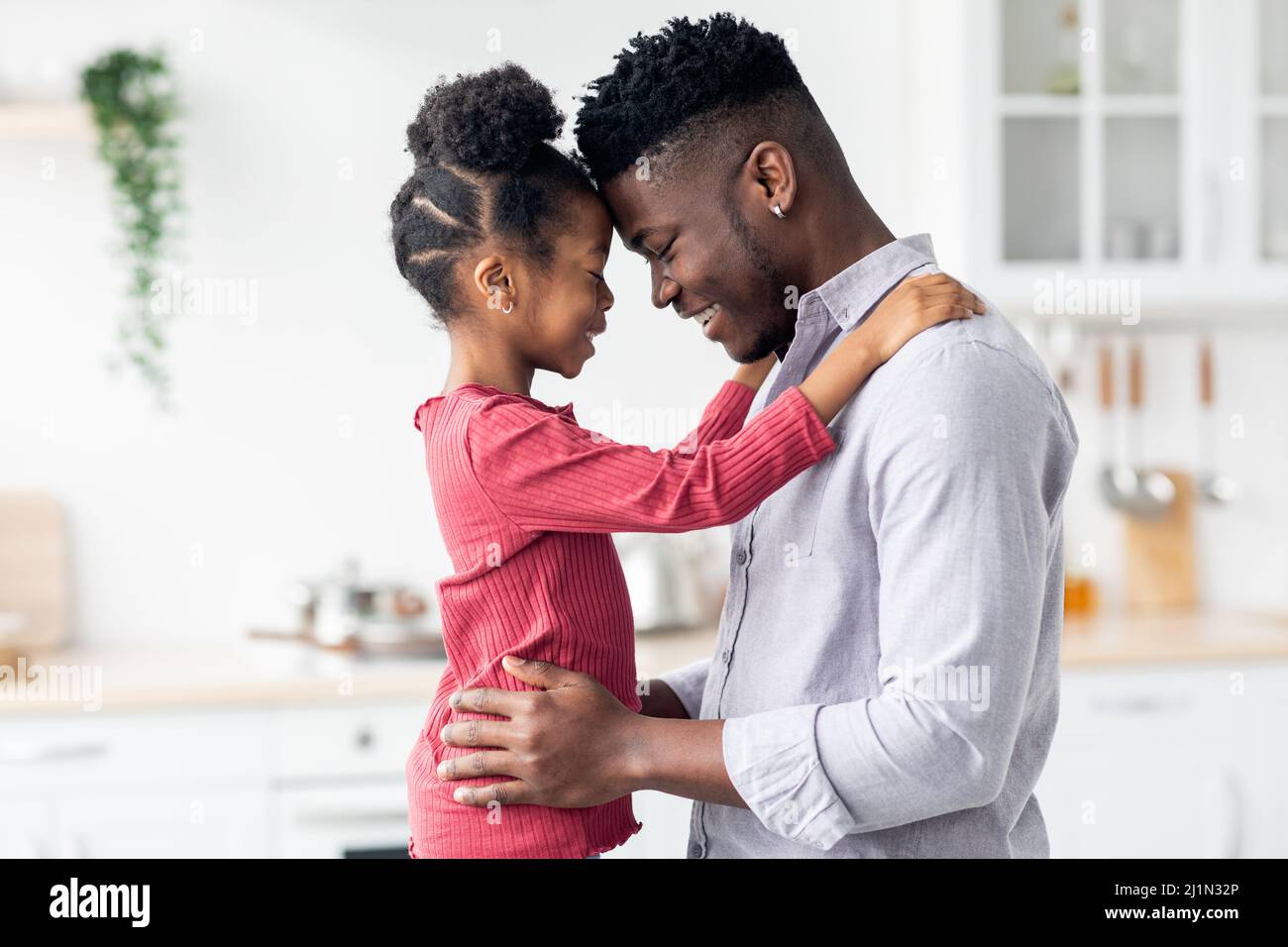 Emotional photo of loving black father and daughter cuddling Stock ...