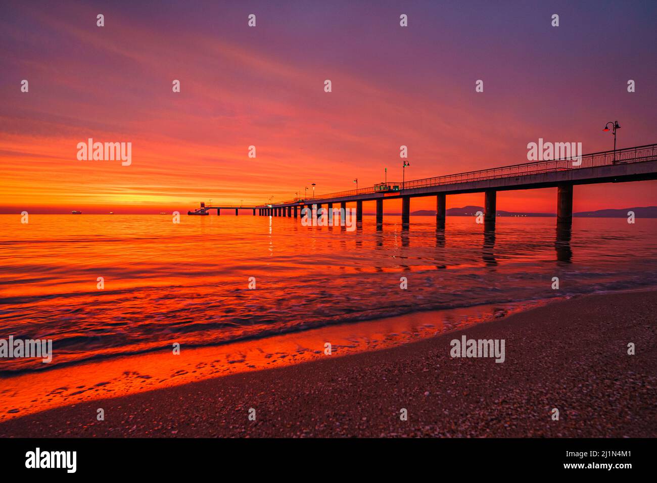 A beautiful shot of a red sunset over the beach and Burgas bridge Stock ...