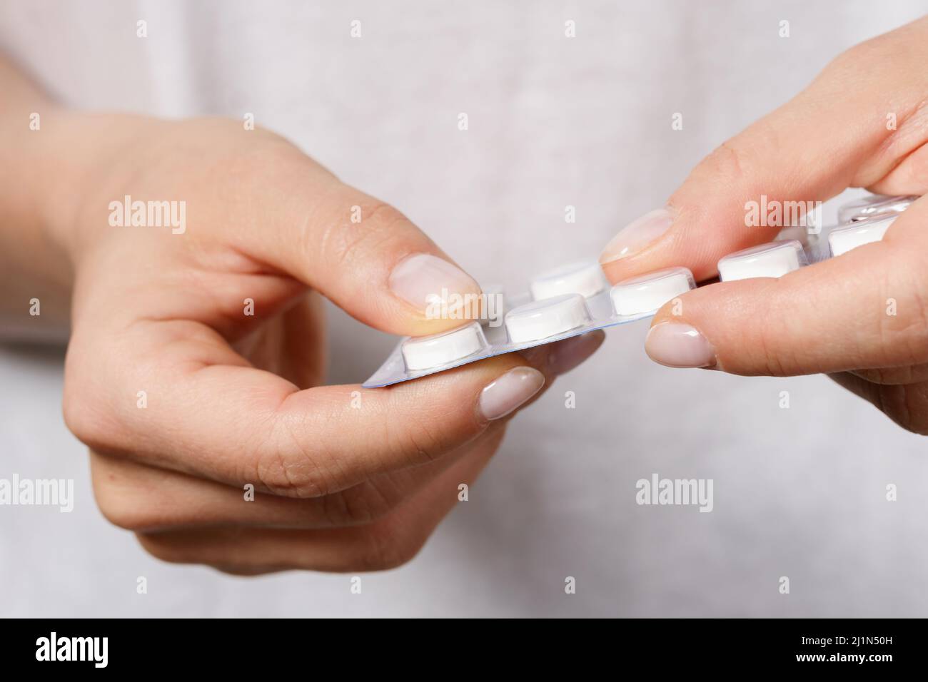 Female hand with a pill in foil packaging Stock Photo - Alamy