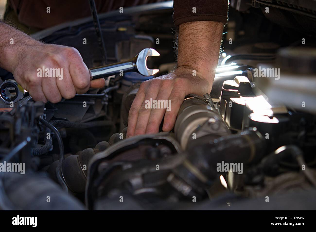 Auto mechanic working on car engine in mechanics garage. Repair service ...