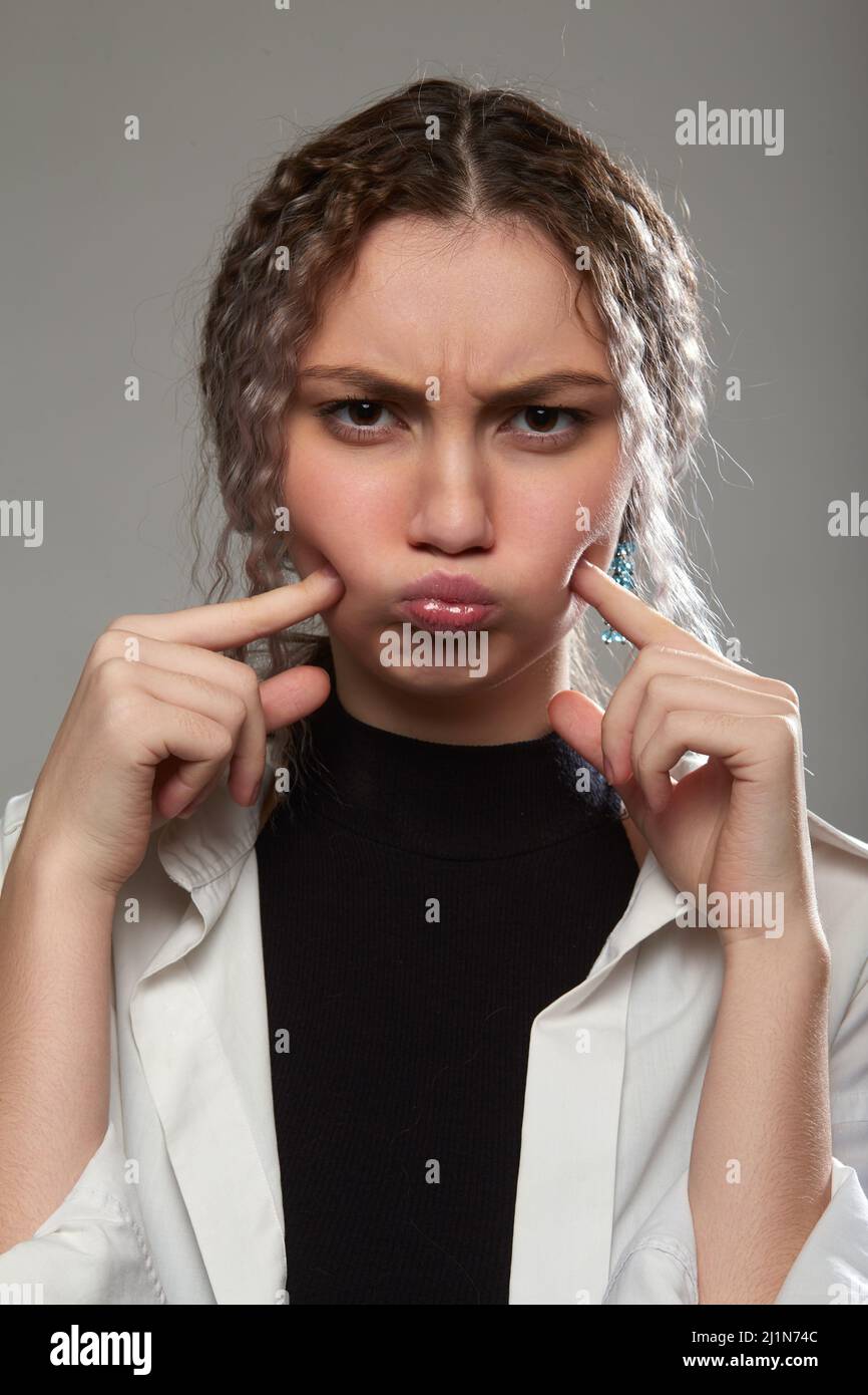 fun pretty girl on gray background making duck face Stock Photo - Alamy