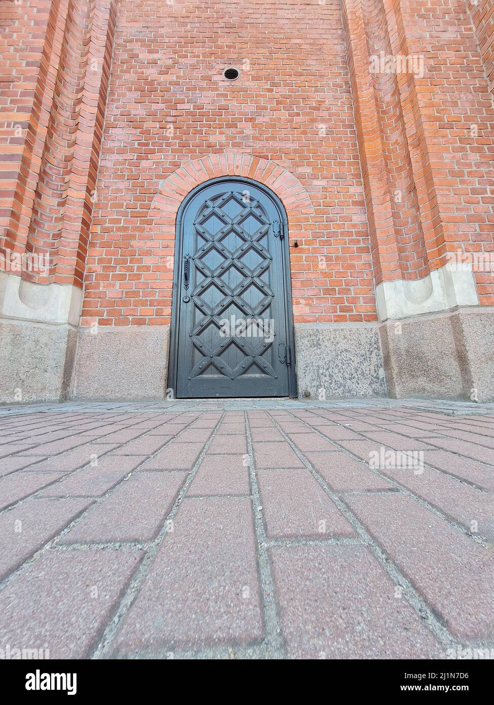 wooden gothic door with red brick wall front view Stock Photo - Alamy