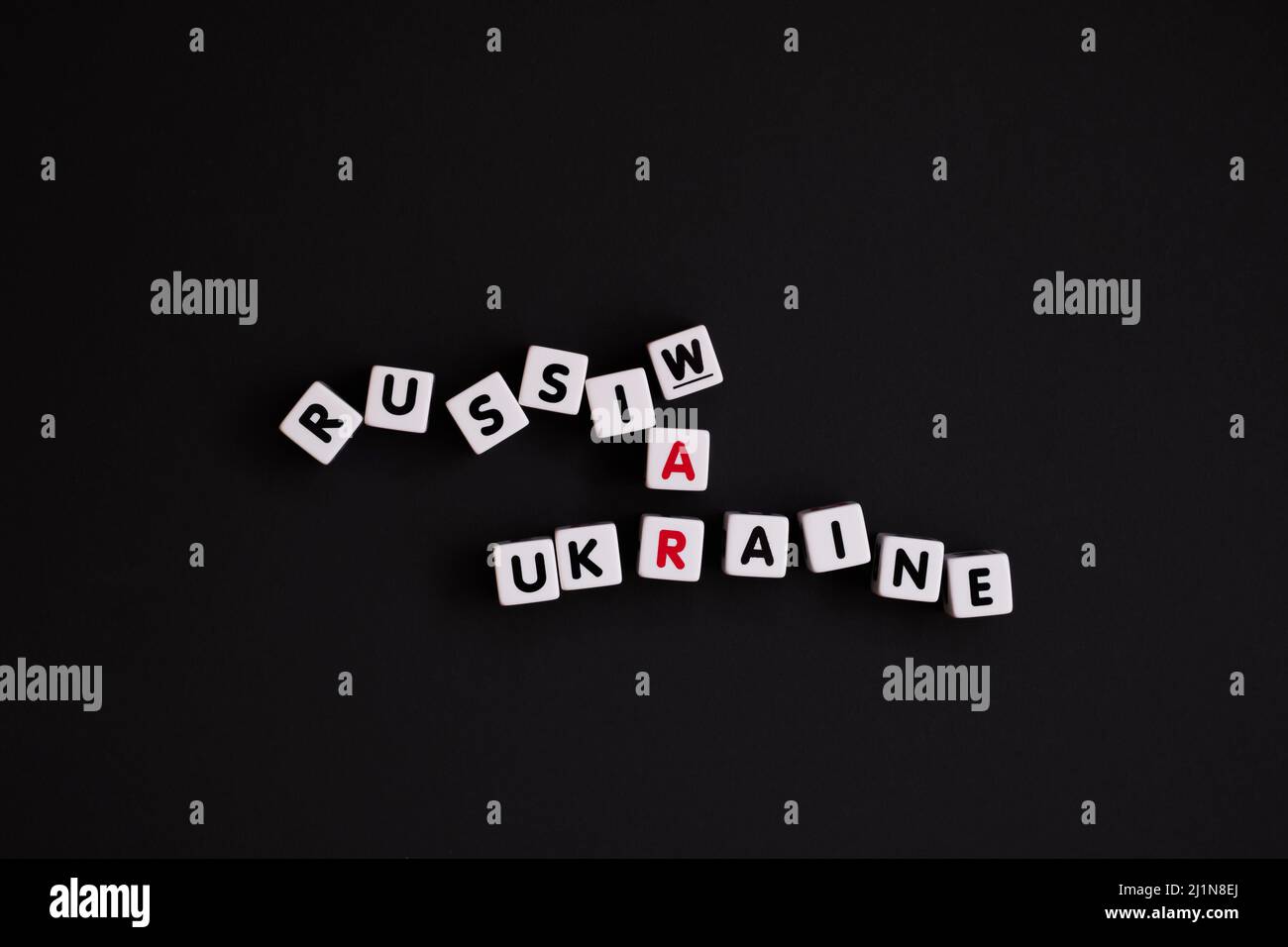 Plastic cubes scattering with the words Russia-Ukrainian war on a black ...