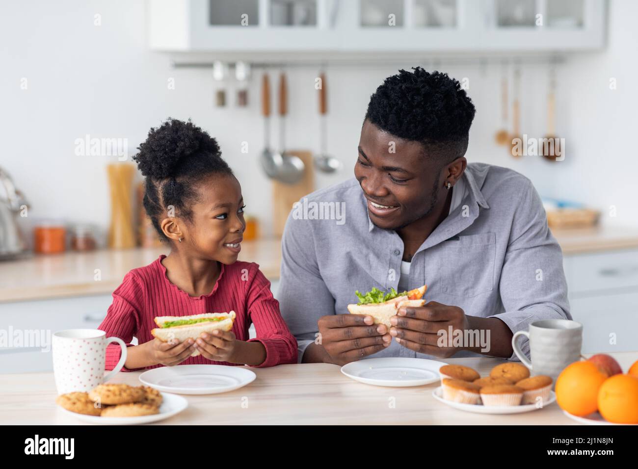 Happy black father and kid having snack at home Stock Photo - Alamy