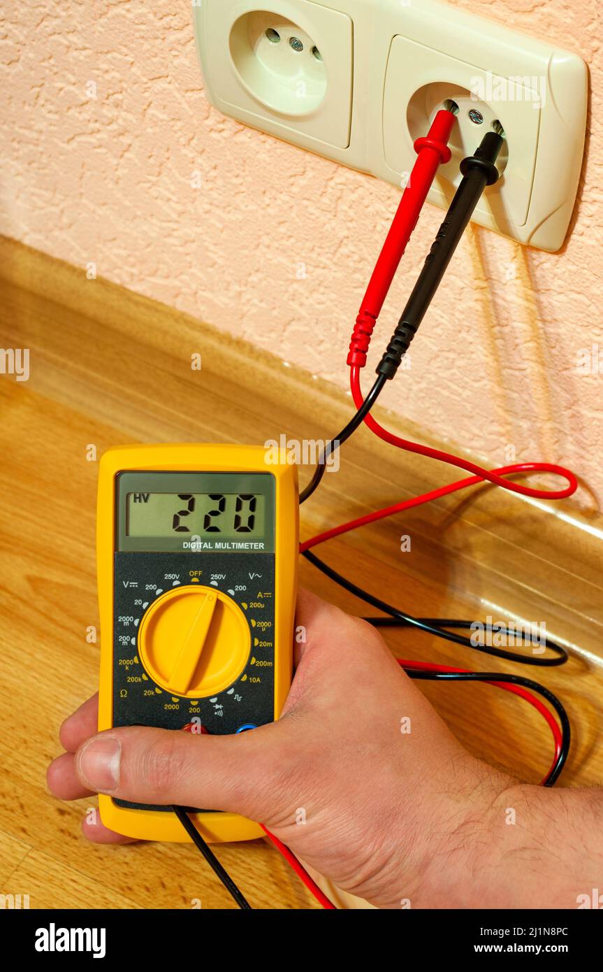 Metering socket voltage with digital multimeter Stock Photo - Alamy