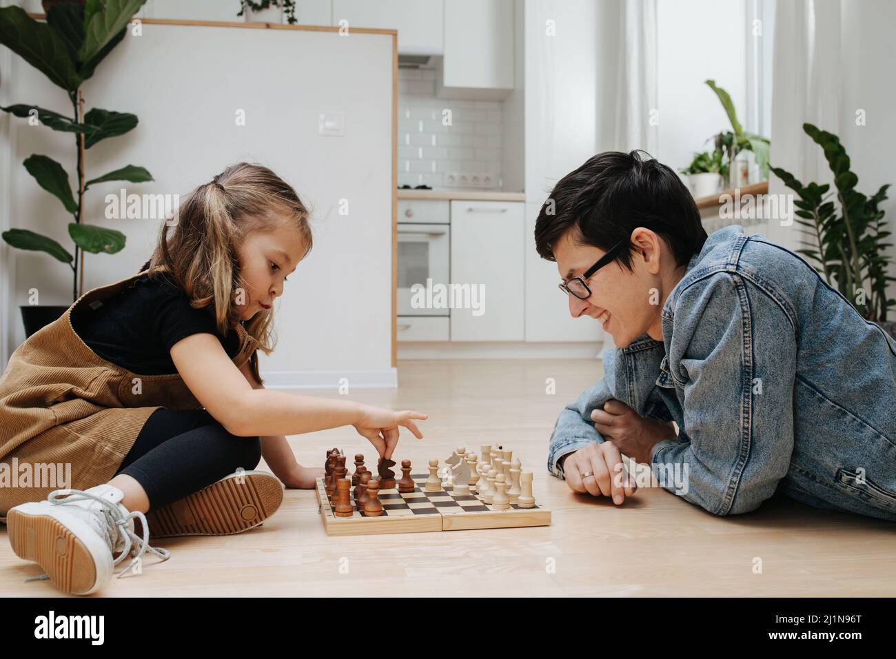 Match of chess between dad and his child daughter. Both excited and ...