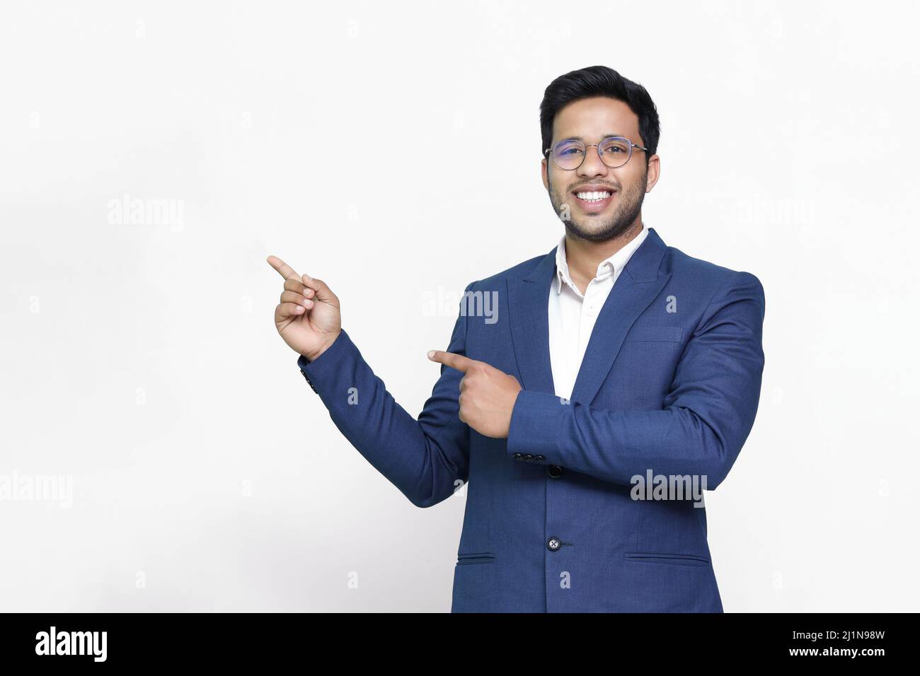 Portrait of a happy businessman pointing finger away over white ...