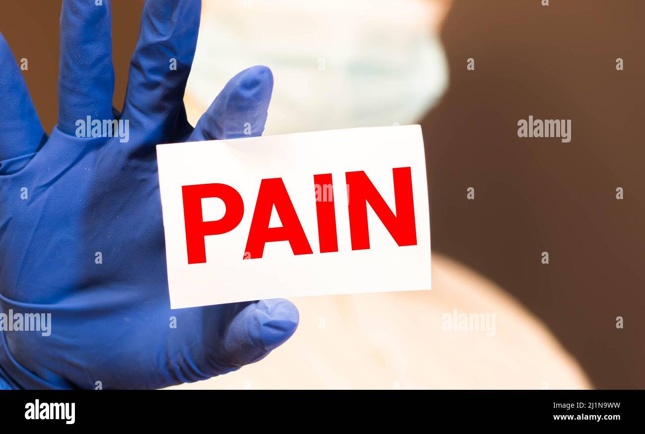 Pain card in hand of Medical Doctor. Healthcare pain relief concept ...