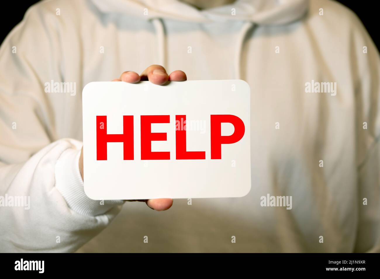 HELP, Teenager with help sign. girl holding a paper with the ...