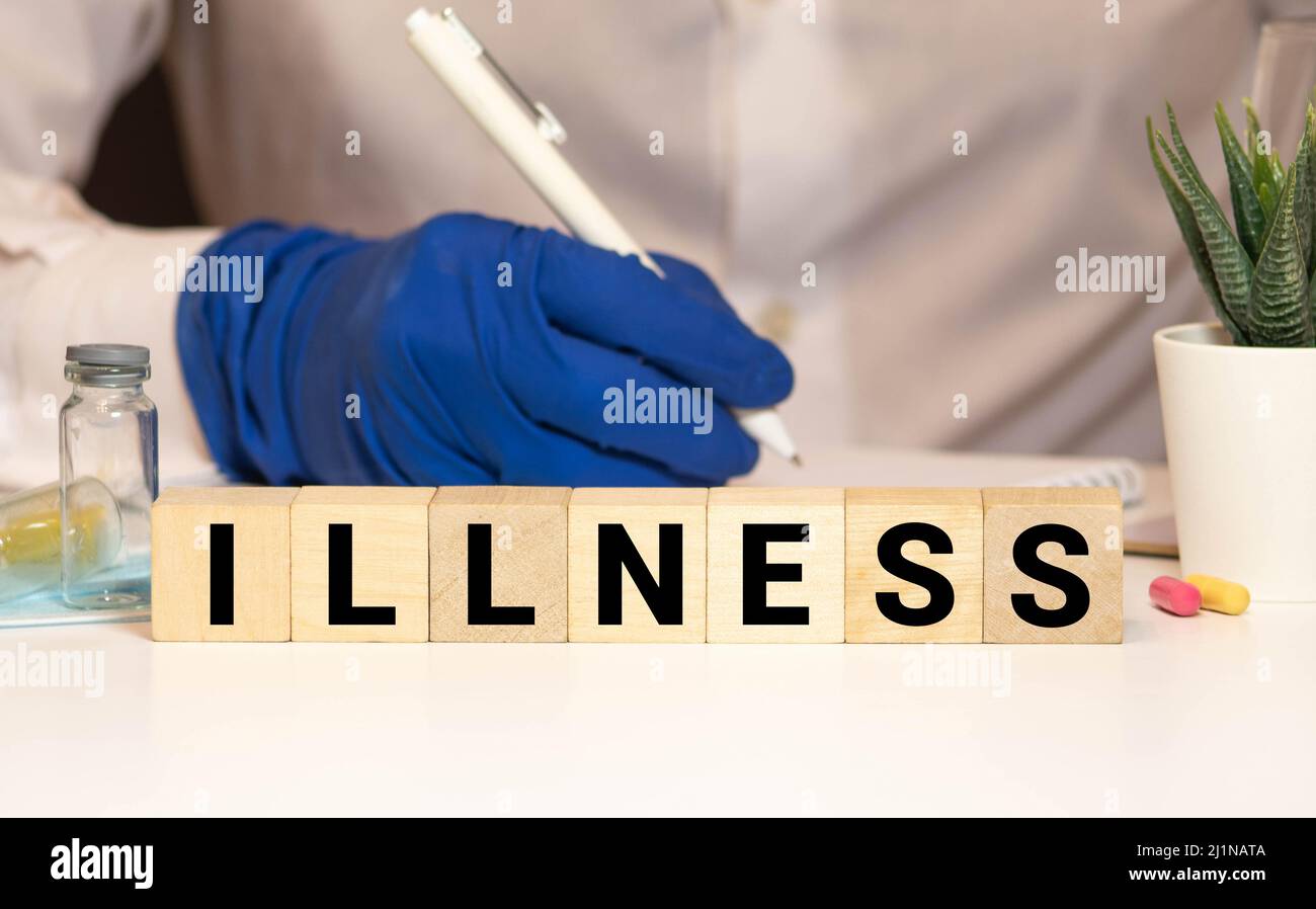 ILLNESS - word from wooden blocks with letters. Side view on gray ...