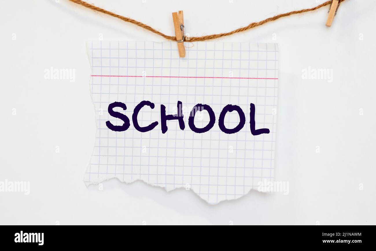 The word school on small pieces of paper on a blue background .The ...