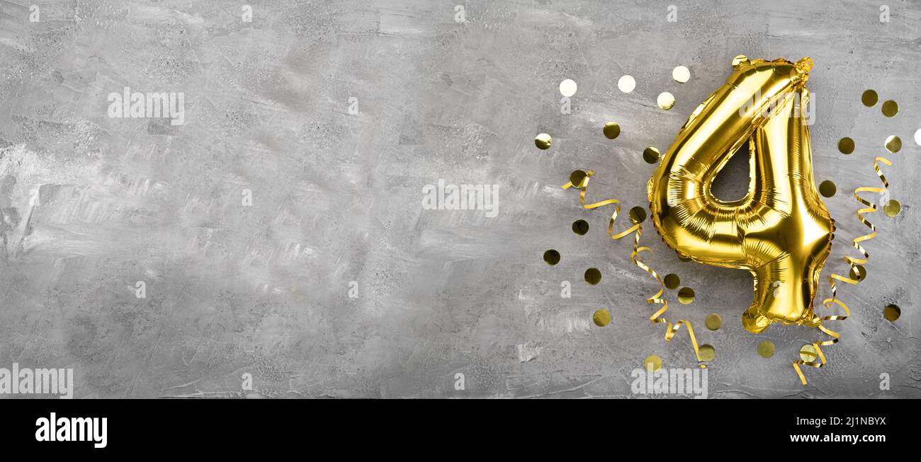 Yellow foil balloon number, number four on a concrete background. 4th ...