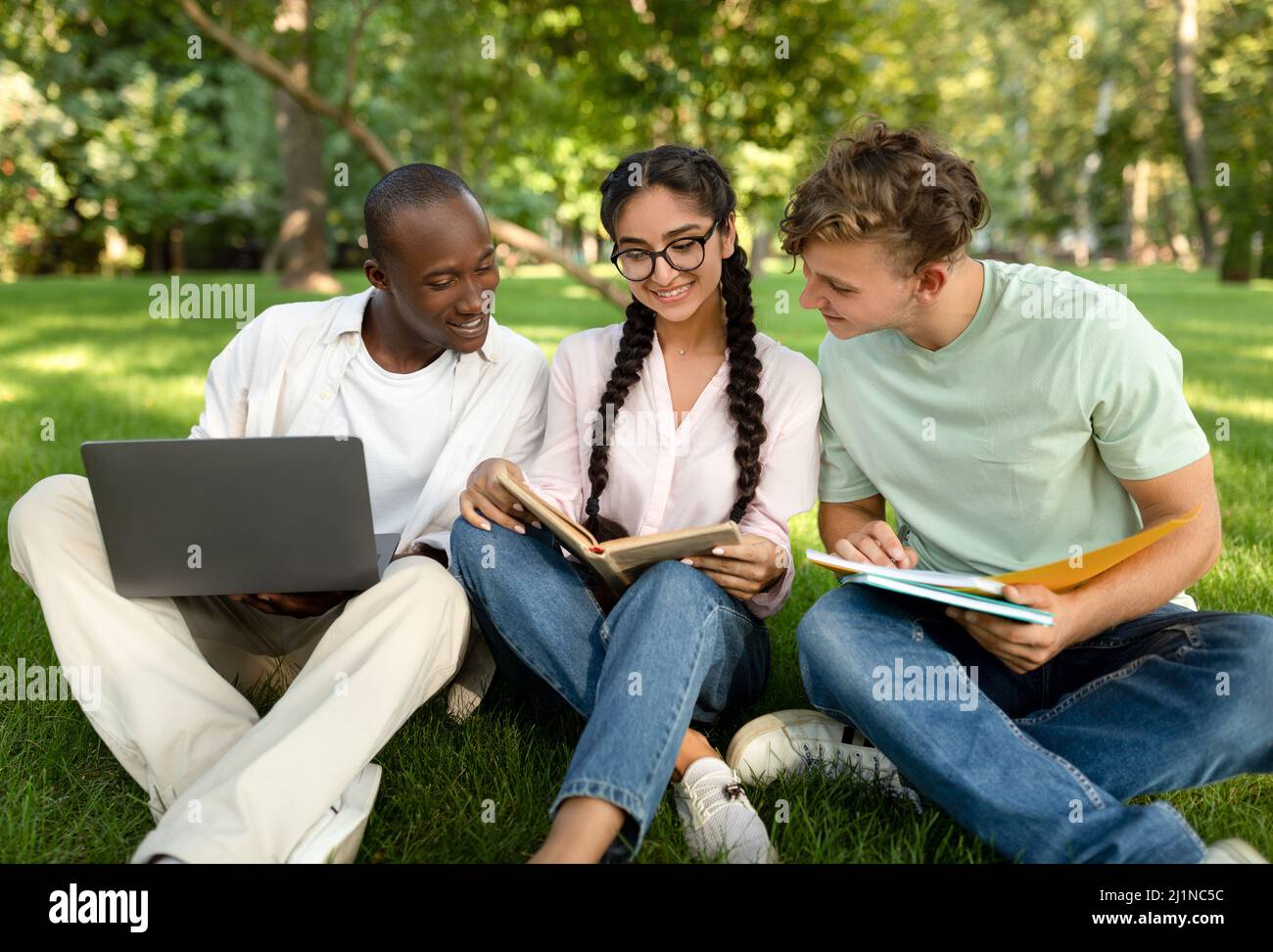 Multiracial students friends learning together, reading books and using ...